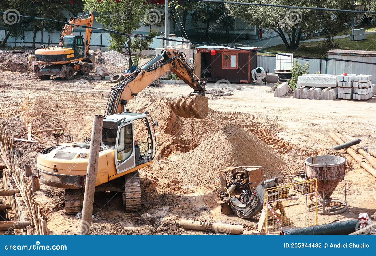 Excavator Digs the Ground at a Construction Site. Stock Photo - Image ...