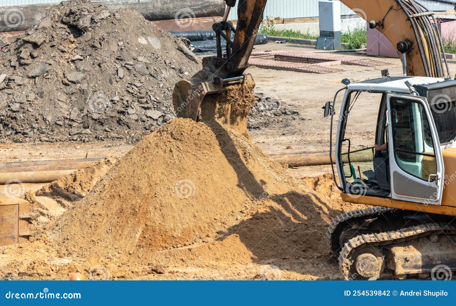 Excavator Digs the Ground at a Construction Site. Stock Photo - Image ...