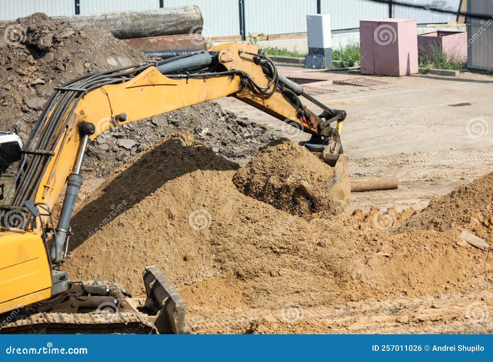 Excavator Digs the Ground at a Construction Site. Stock Photo - Image ...