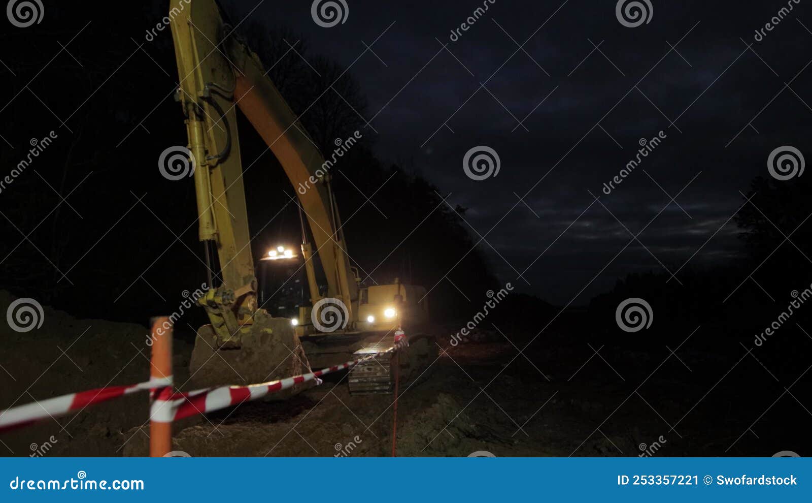 An Excavator with Headlights on Stands at a Construction Site in the ...