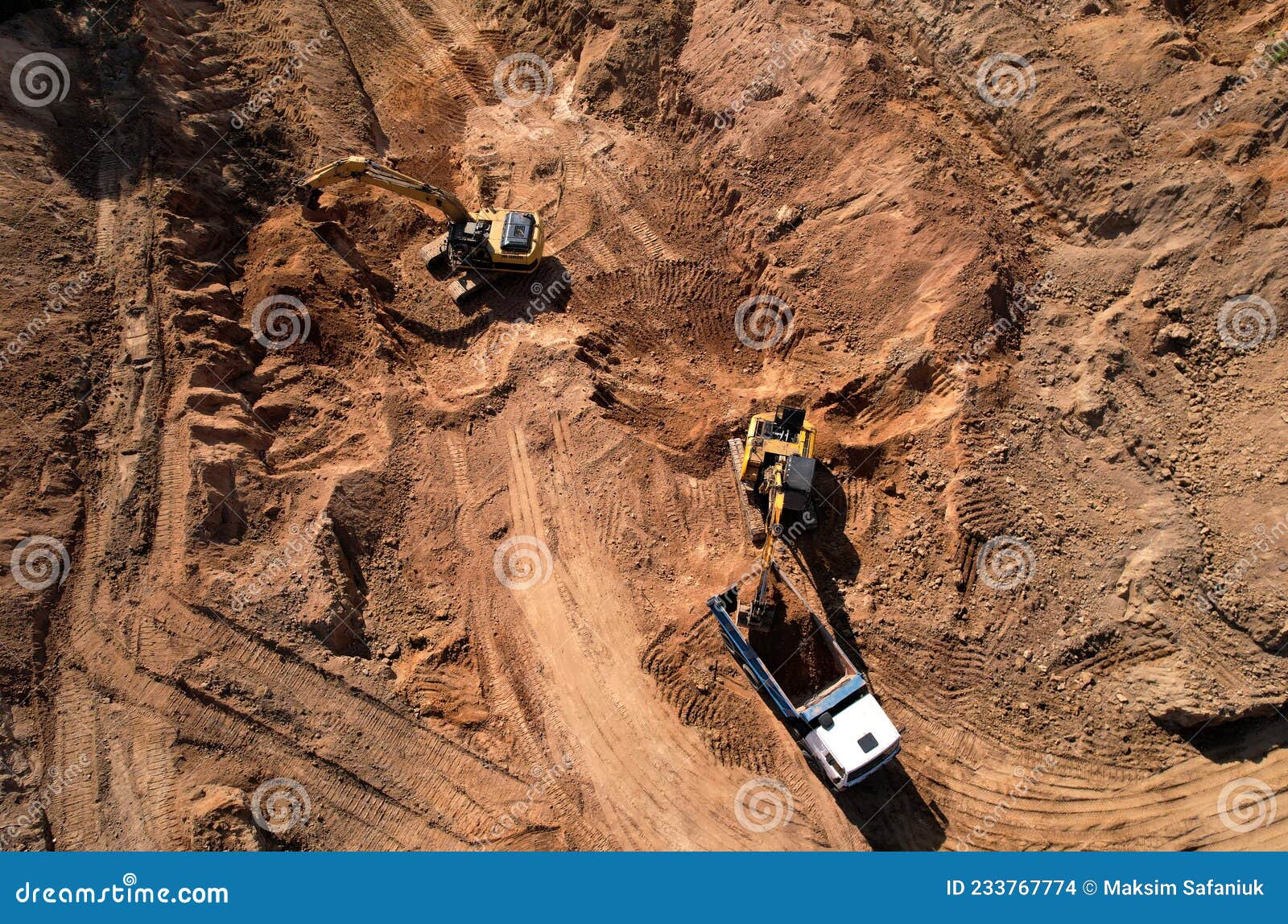 Excavator Load the Sand into Dump Truck. Aerial View of an Backhoe on ...