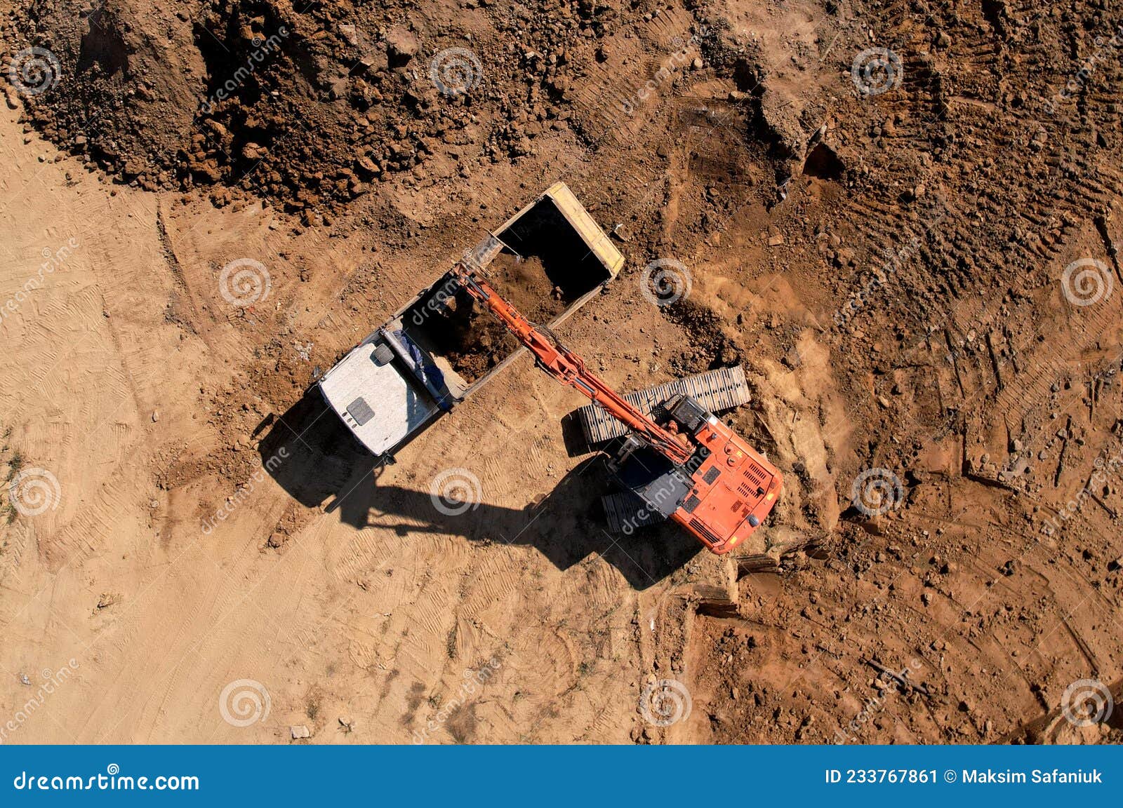 Excavator Load the Sand into Dump Truck. Aerial View of an Backhoe on ...