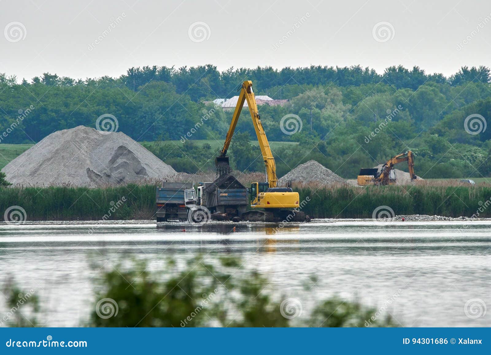 Excavator Loading a Truck on a Lake Stock Photo - Image of clouds ...