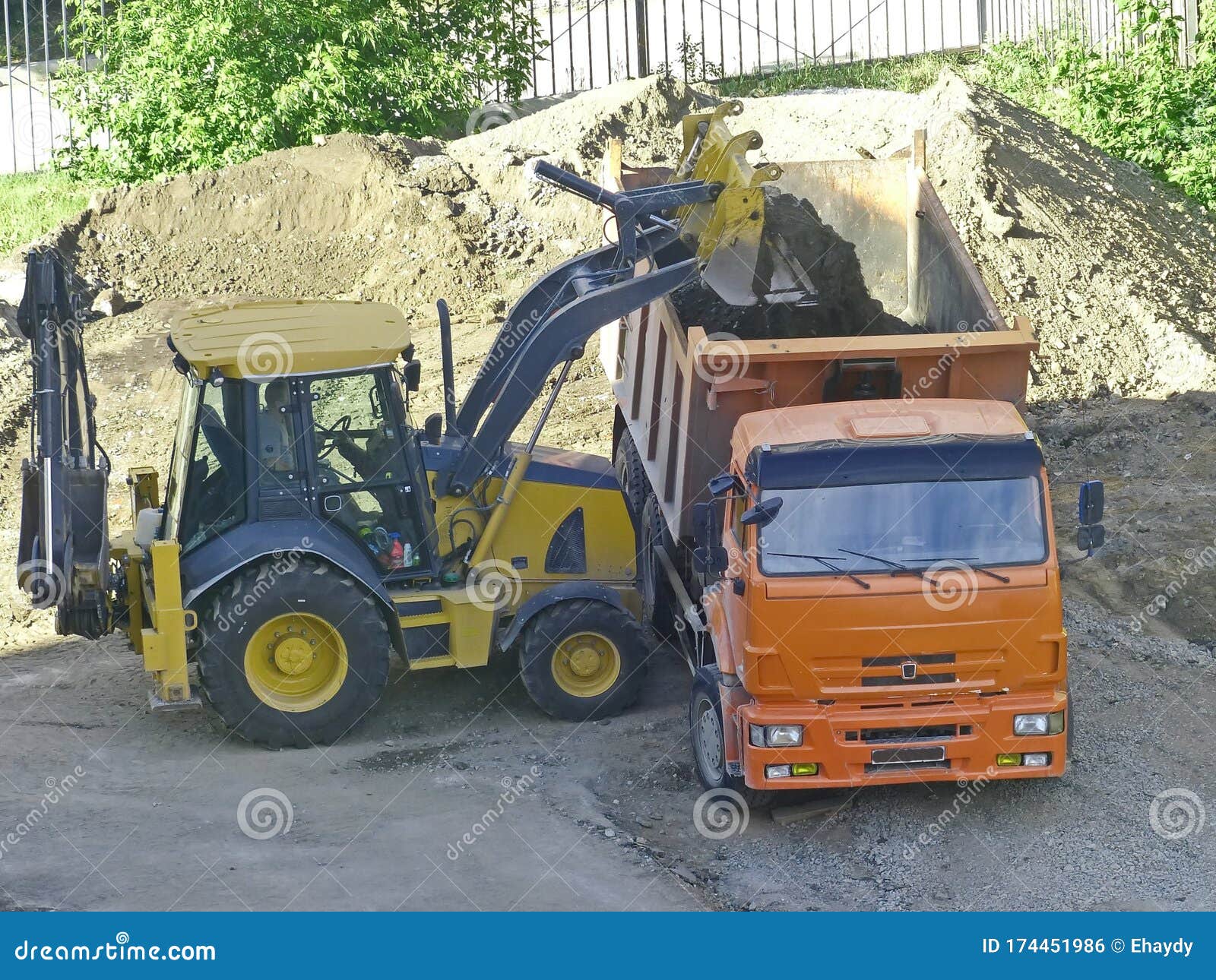 The Excavator Loads the Dump Truck with Soil. Loading Operations, Road ...