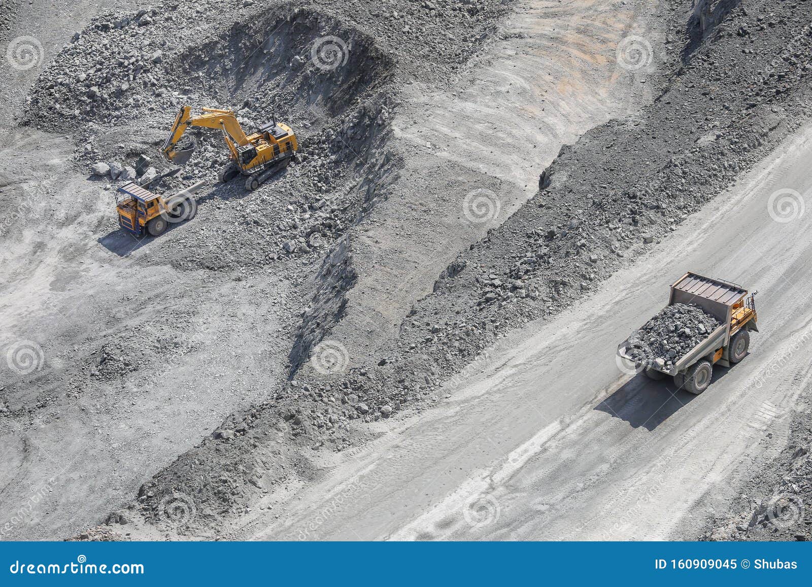 Excavator Loads Ore into a Large Mining Dump Truck. Top View Stock ...
