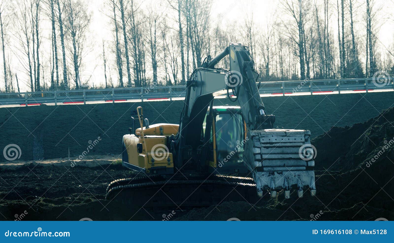 Excavator in the Process of Leveling the Slope of the Road Stock Photo ...