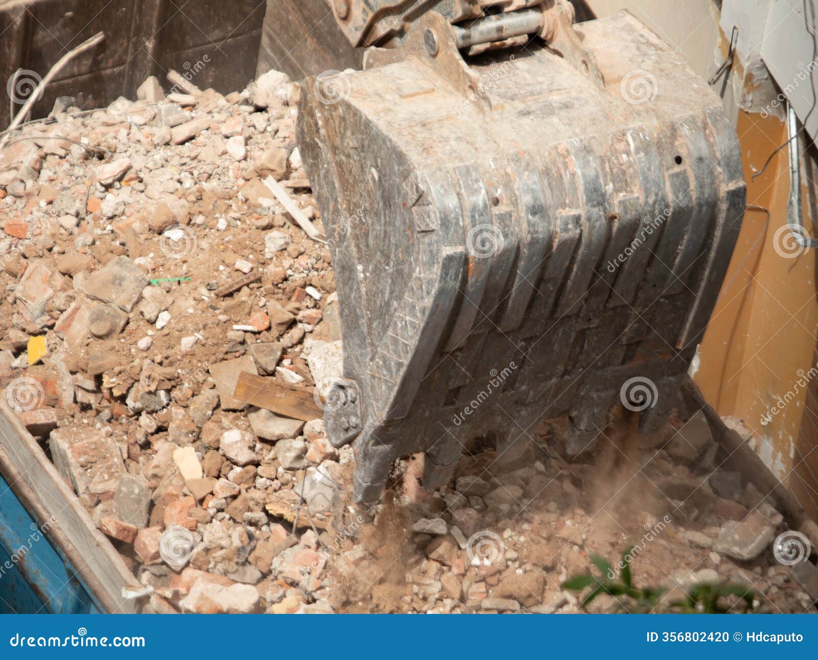 Excavator Removing Debris from a Demolition Site and Dumping it into ...