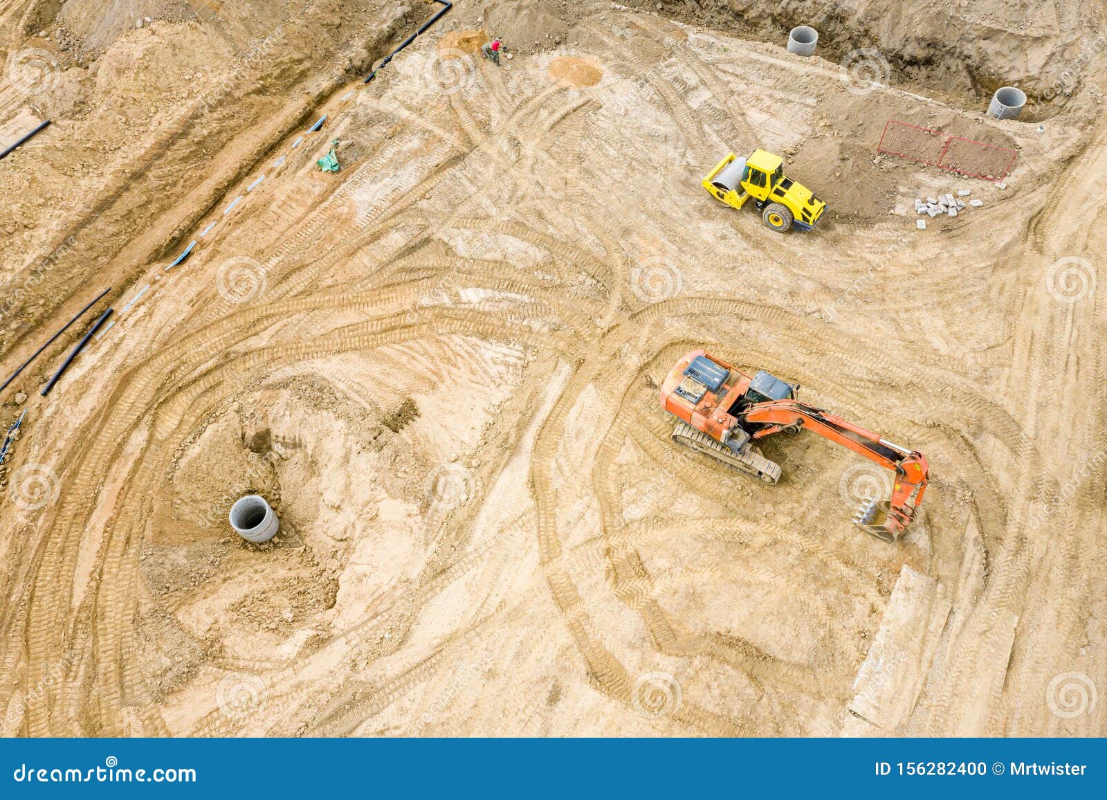 Excavator and Roller Flattening the Ground at Construction Site Stock ...