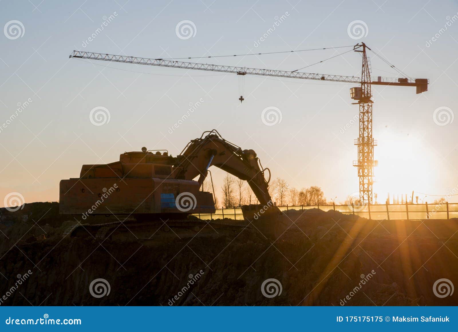 Excavator and Tower Crane at Construction Site on Sunset Background ...