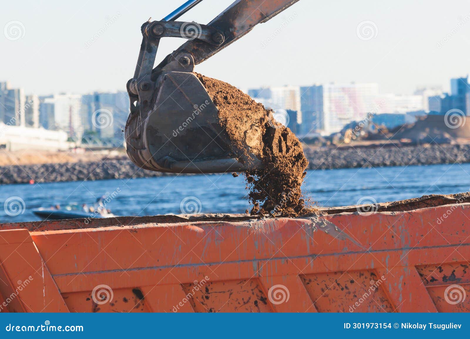 Excavator Unloading Sand into the Dump Truck on the Construction Site ...