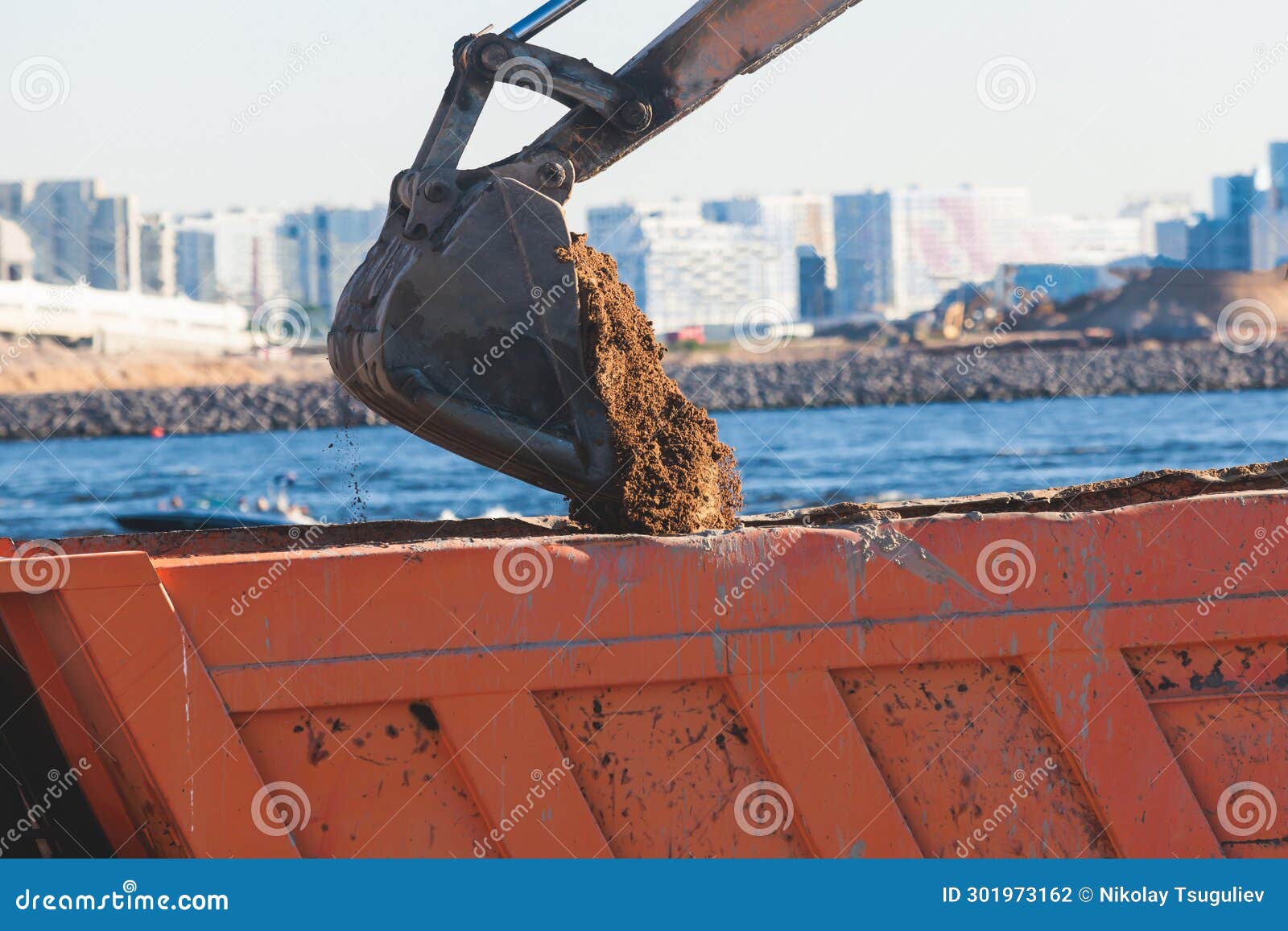Excavator Unloading Sand into the Dump Truck on the Construction Site ...