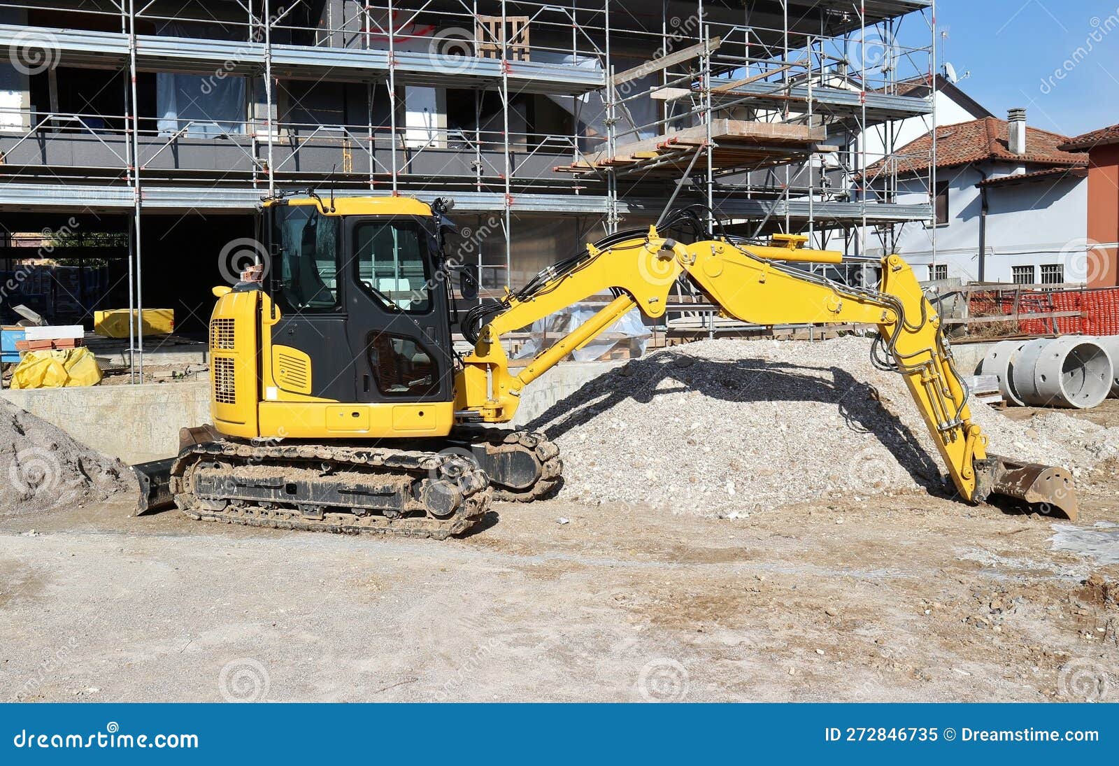 Excavator at Work in Front of Residential Building Under Construction ...