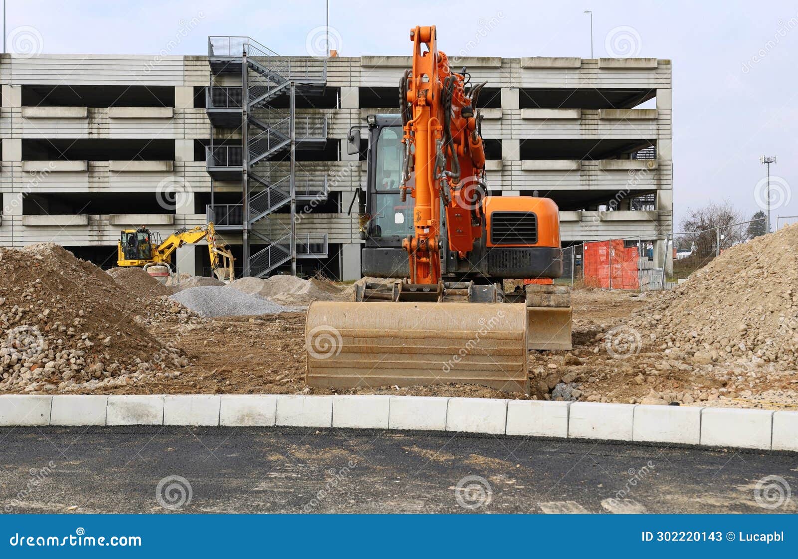 Excavator at Work in the Land Outside a Modern Industrial Concrete ...