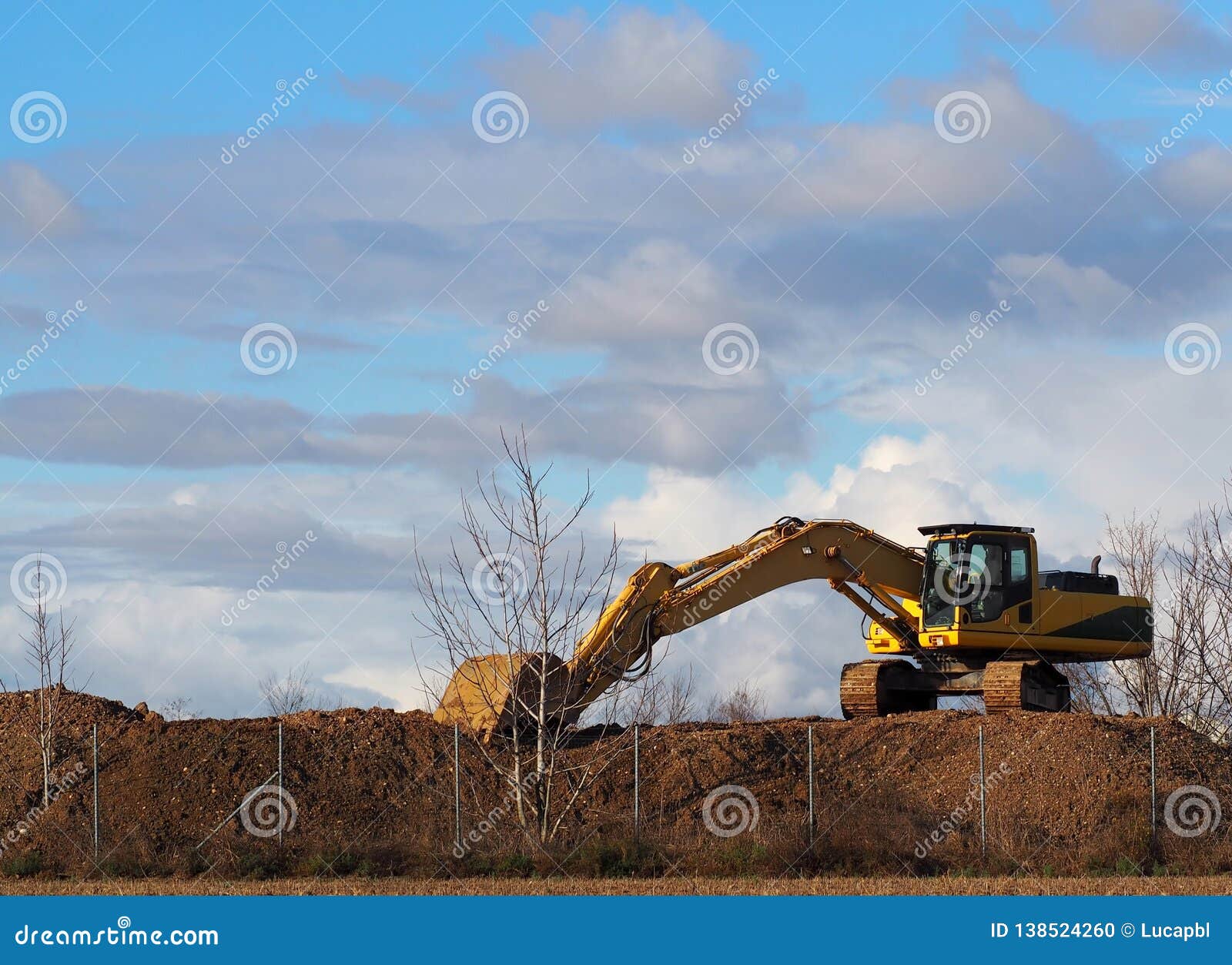 Excavator at Work in a New Development Area Under a Blue Sky with ...