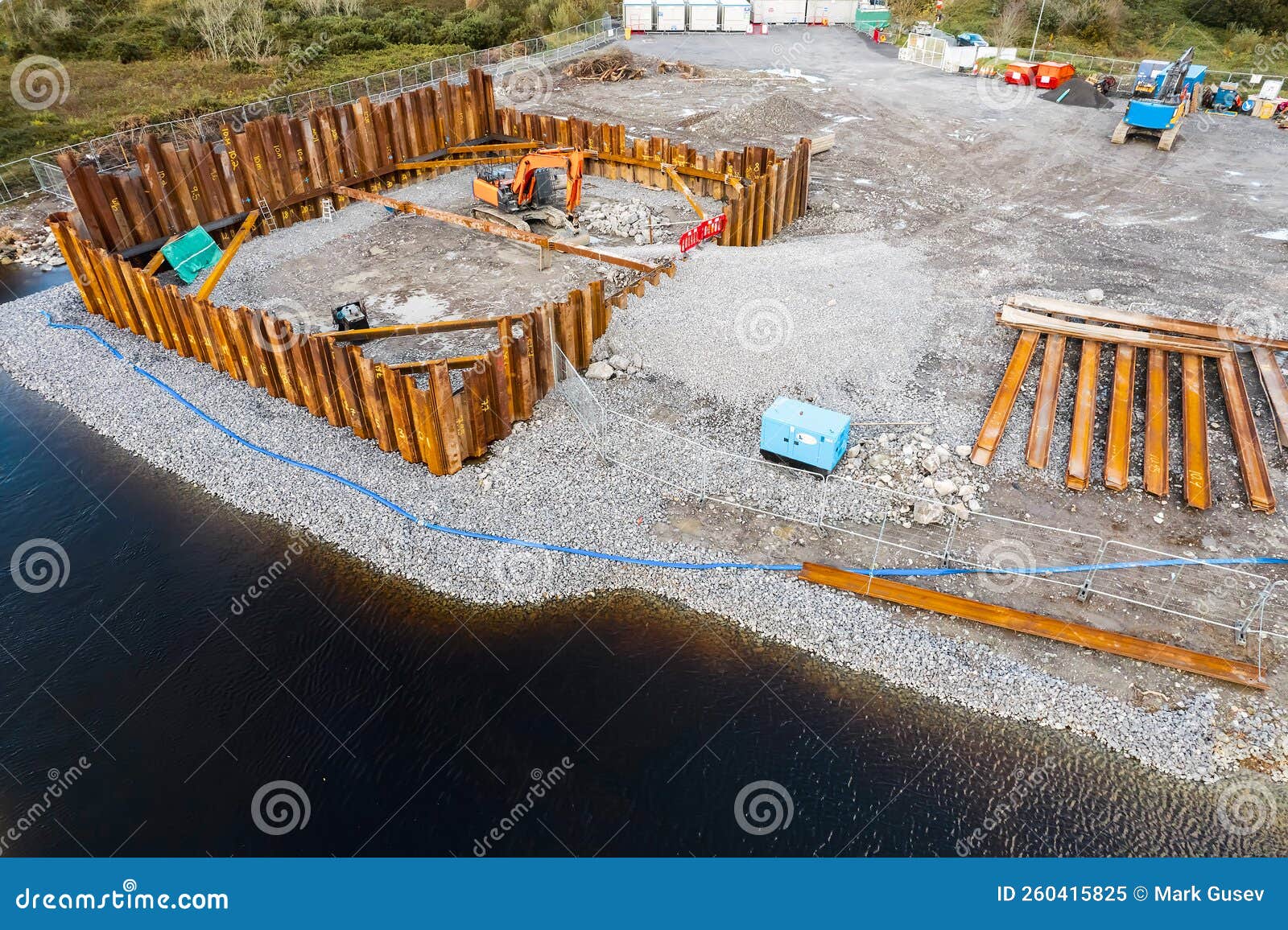 Excavator Working in Metal Frame Structure by a River. Construction ...