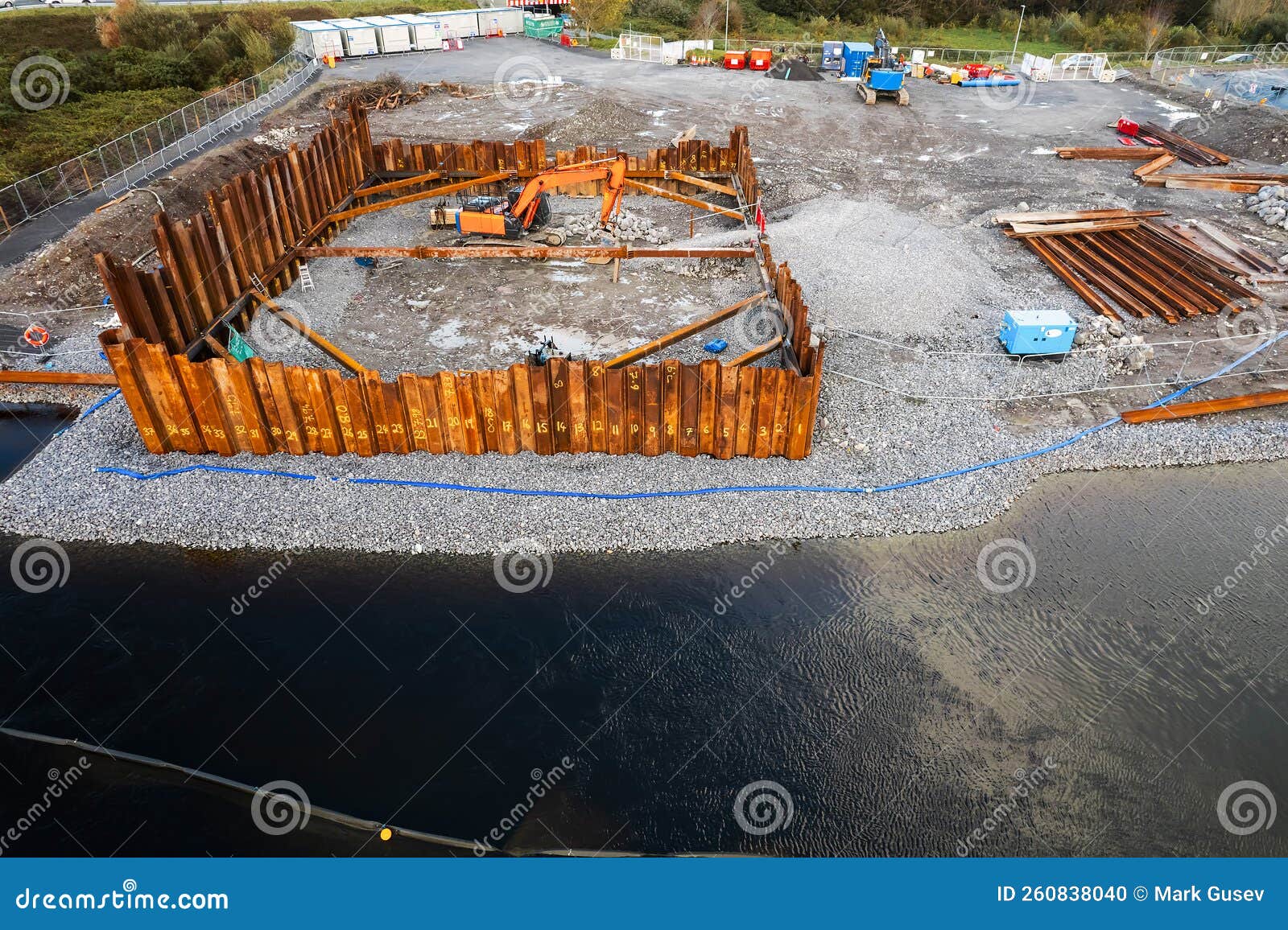Excavator Working in Metal Frame Structure by a River. Construction ...
