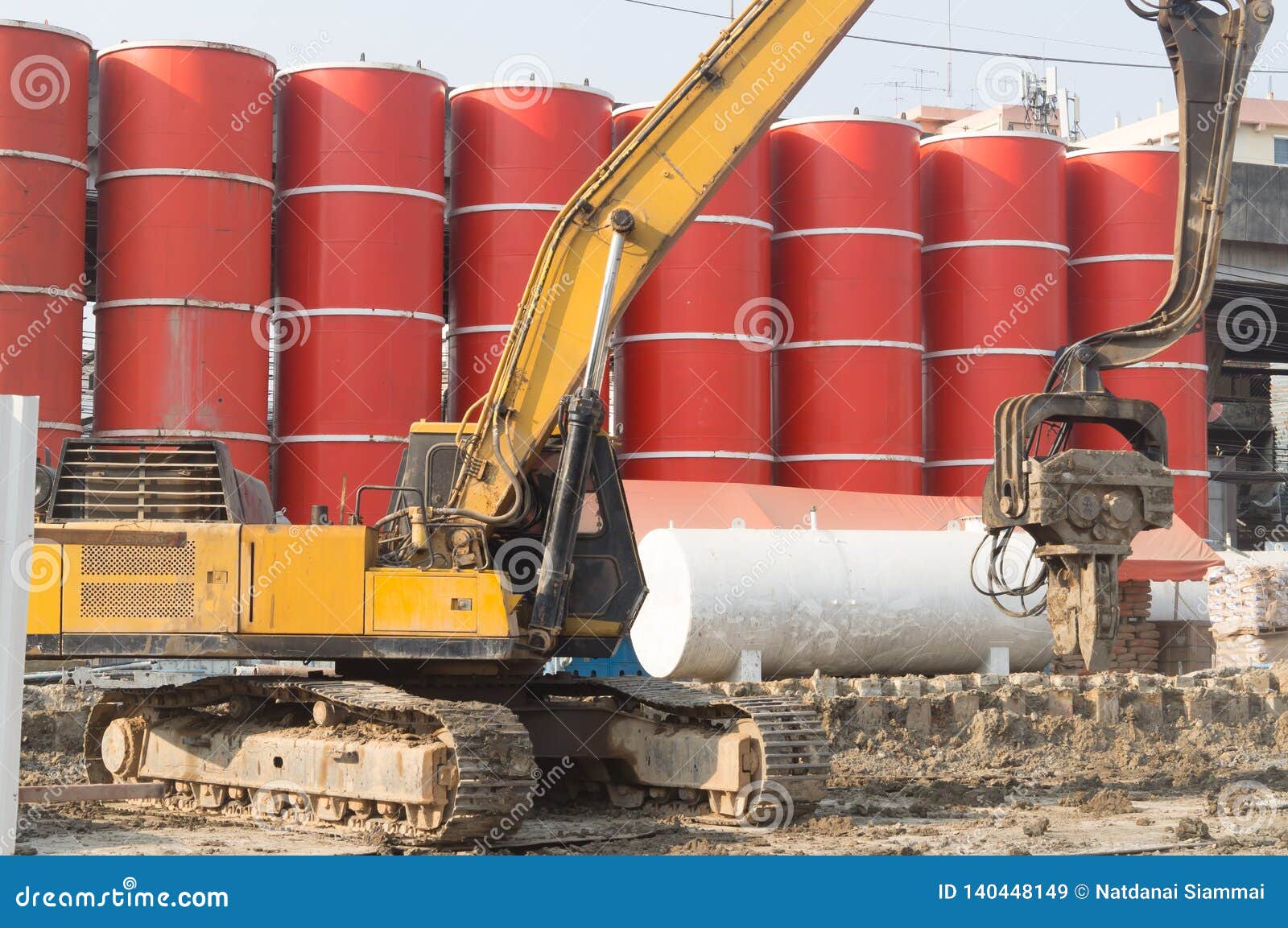 Excavator Working beside Red Drilling Solution Tanks at Construction ...