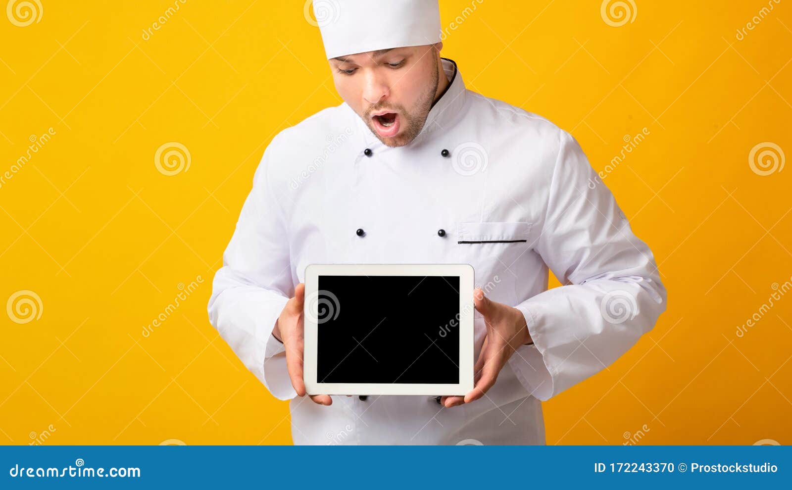 Excited Chef Looking at Tablet Screen Standing, Yellow Background ...