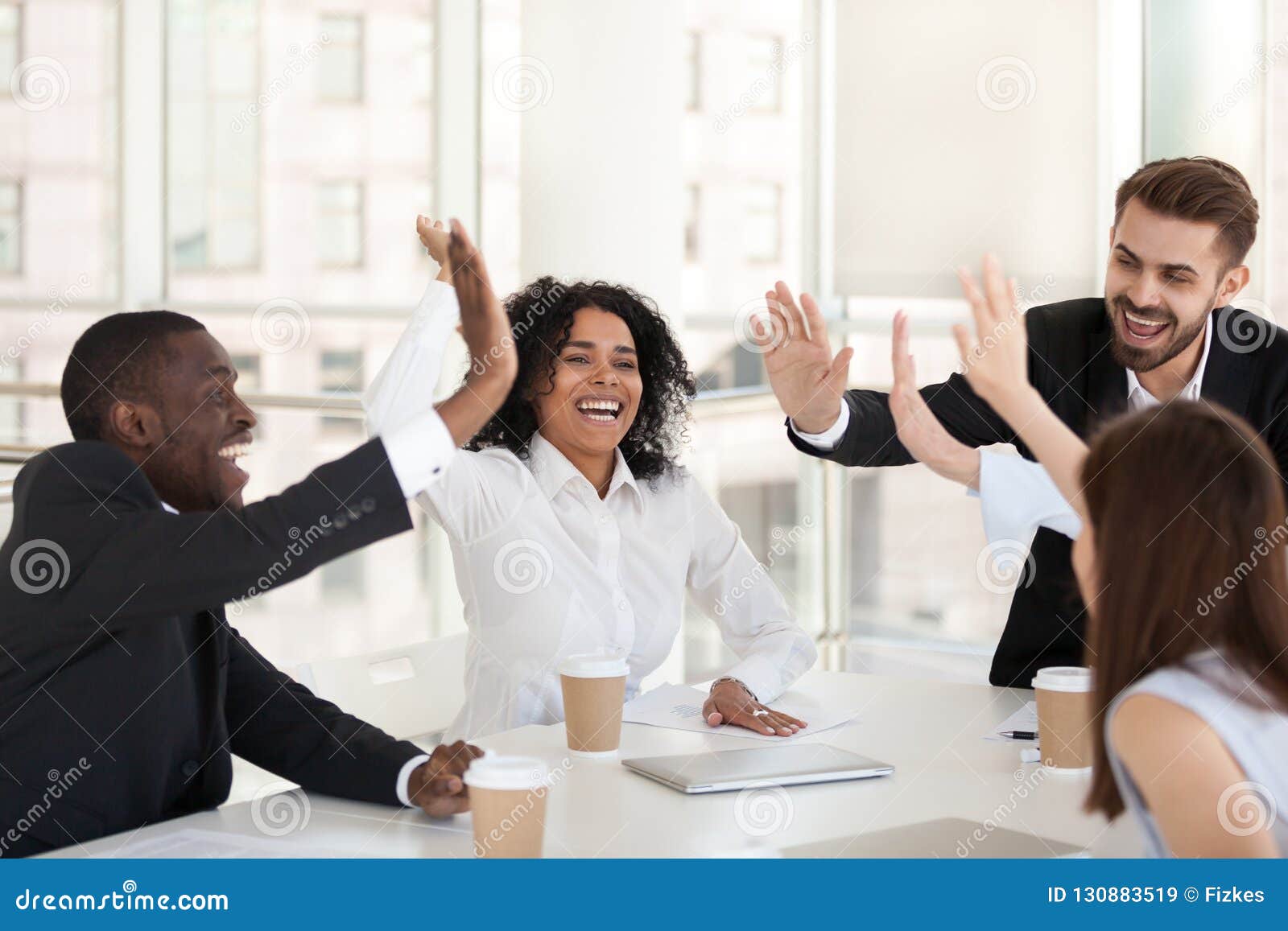 Excited Diverse Employees Give High Five At Team Meeting Stock Image