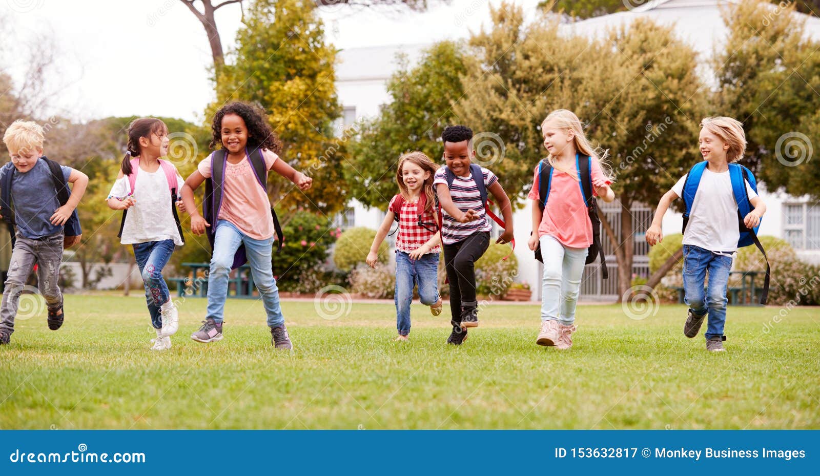Excited Elementary School Pupils Running Across Field at Break Time ...