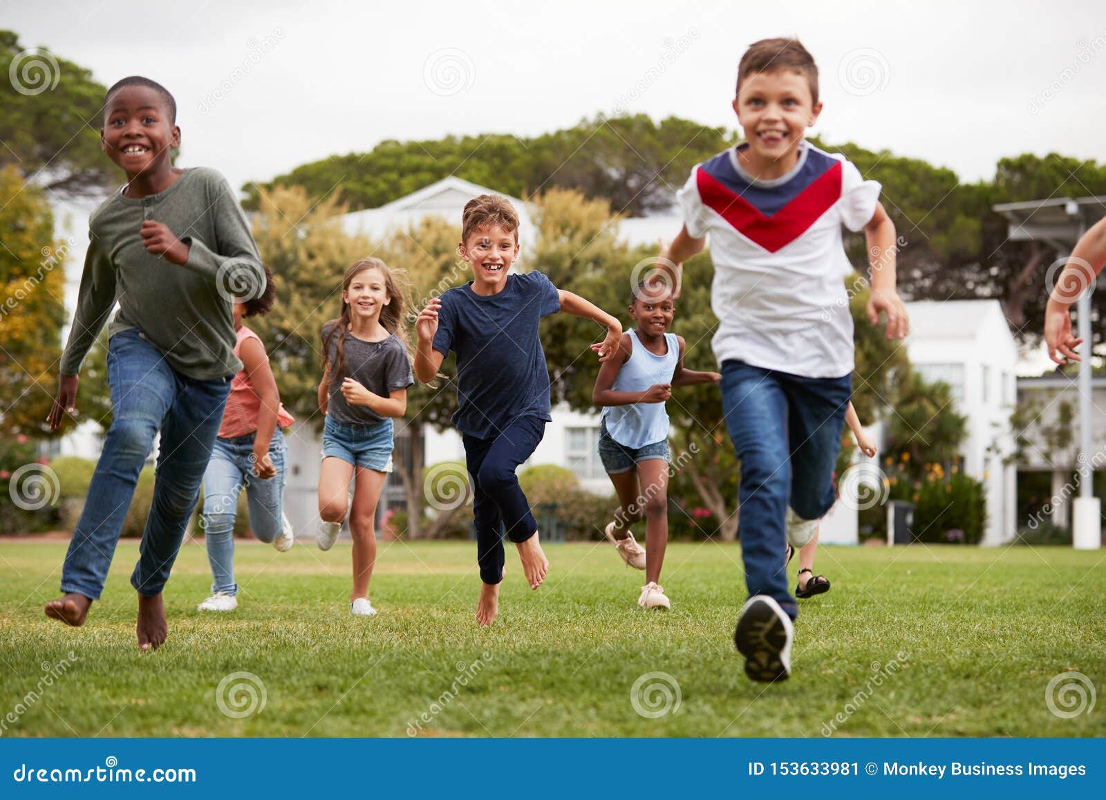 Excited Elementary School Pupils Running Across Field at Break Time ...