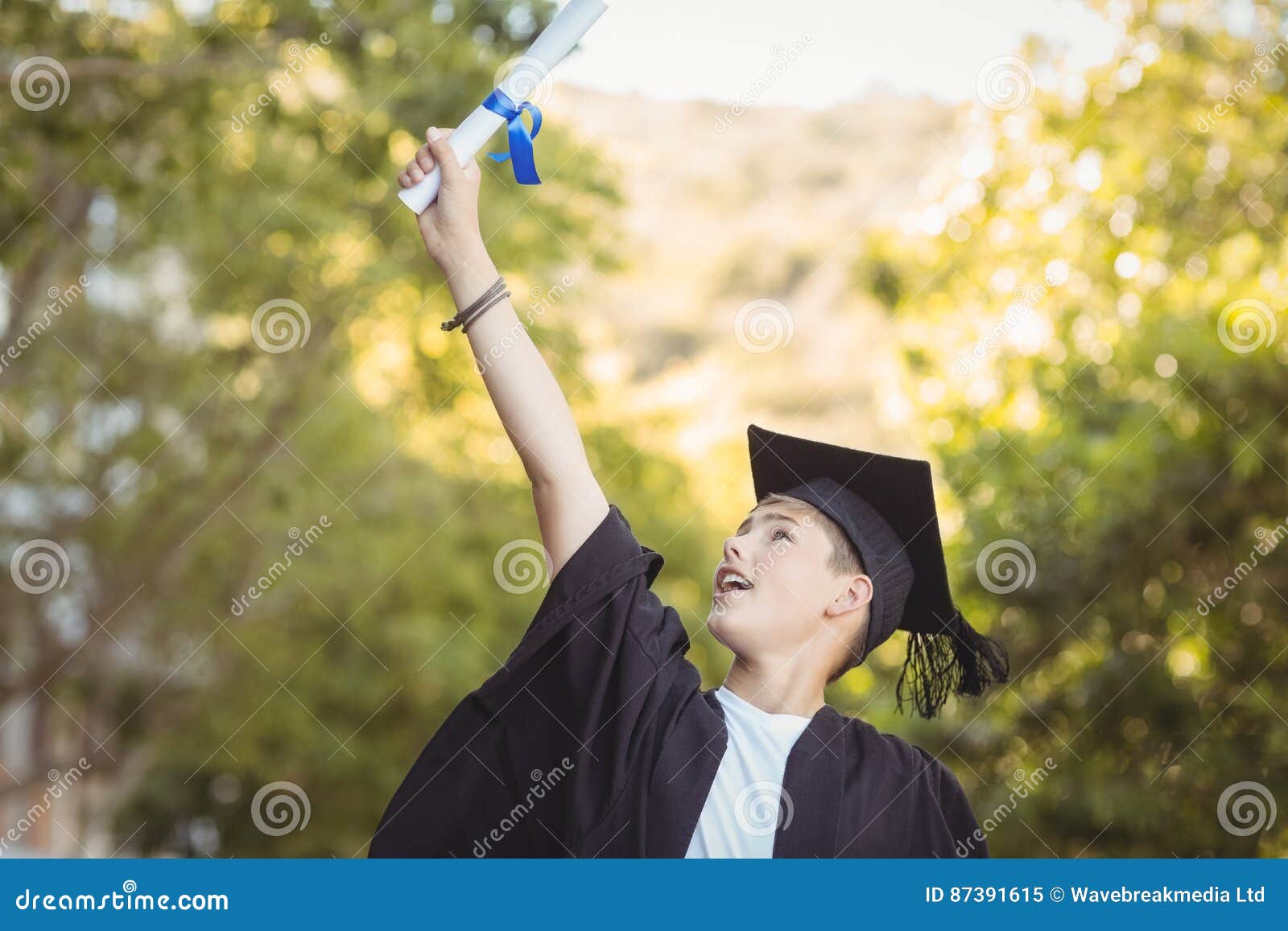 Excited Graduate Schoolboy with Degree Scroll in Campus Stock Image ...