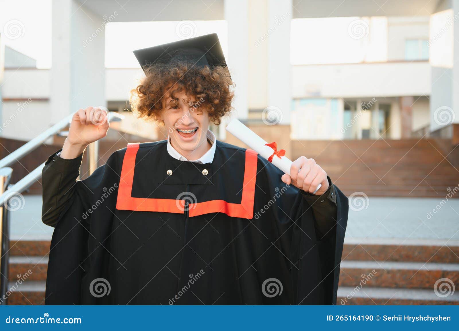 Excited Graduate Student in Gown with Risen Hands Holding Diploma ...