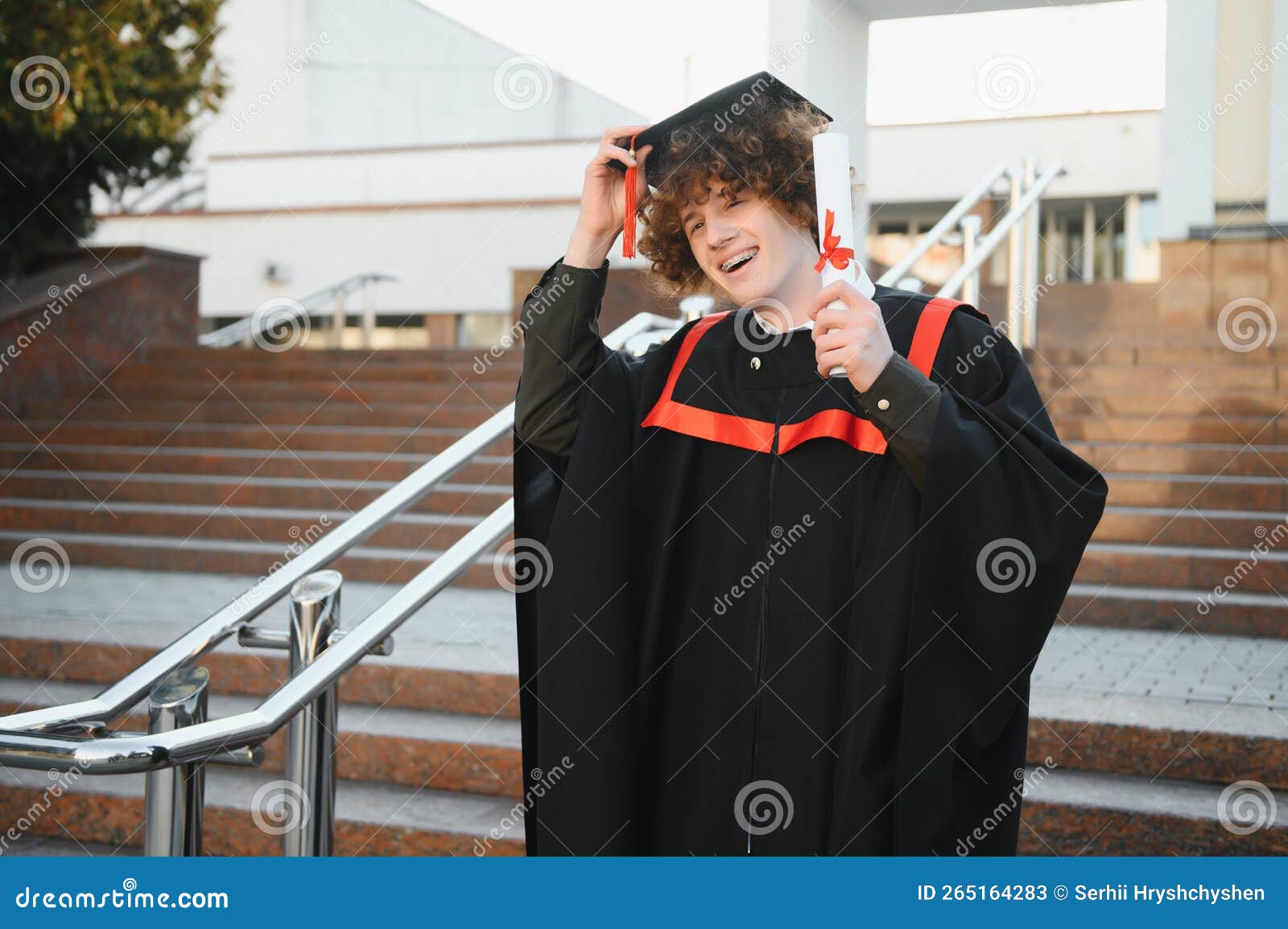 Excited Graduate Student in Gown with Risen Hands Holding Diploma ...