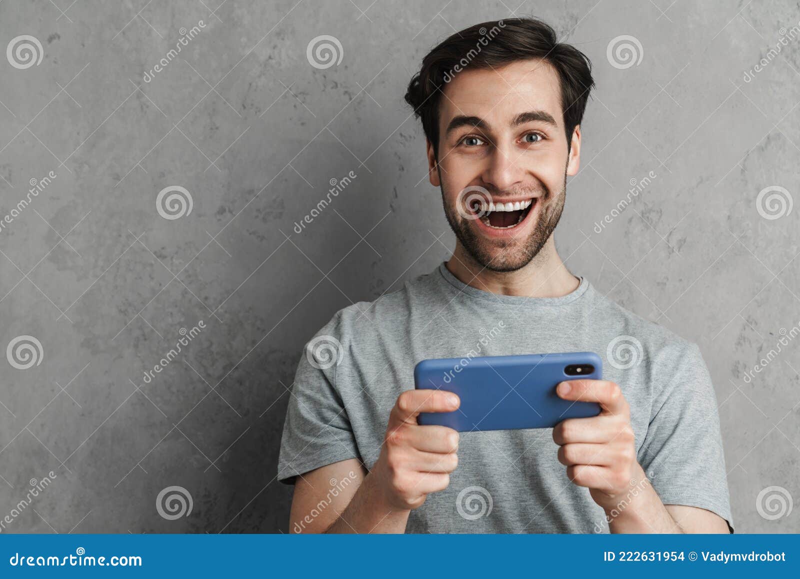 Excited Handsome Guy Laughing and Using Mobile Phone Stock Photo ...