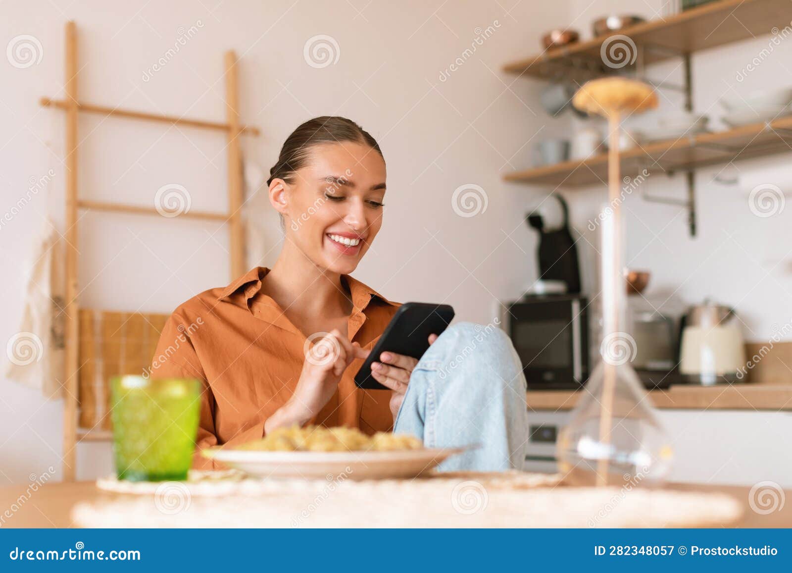 Excited Lady Using Smartphone in Kitchen while Having Dinner, Sitting ...