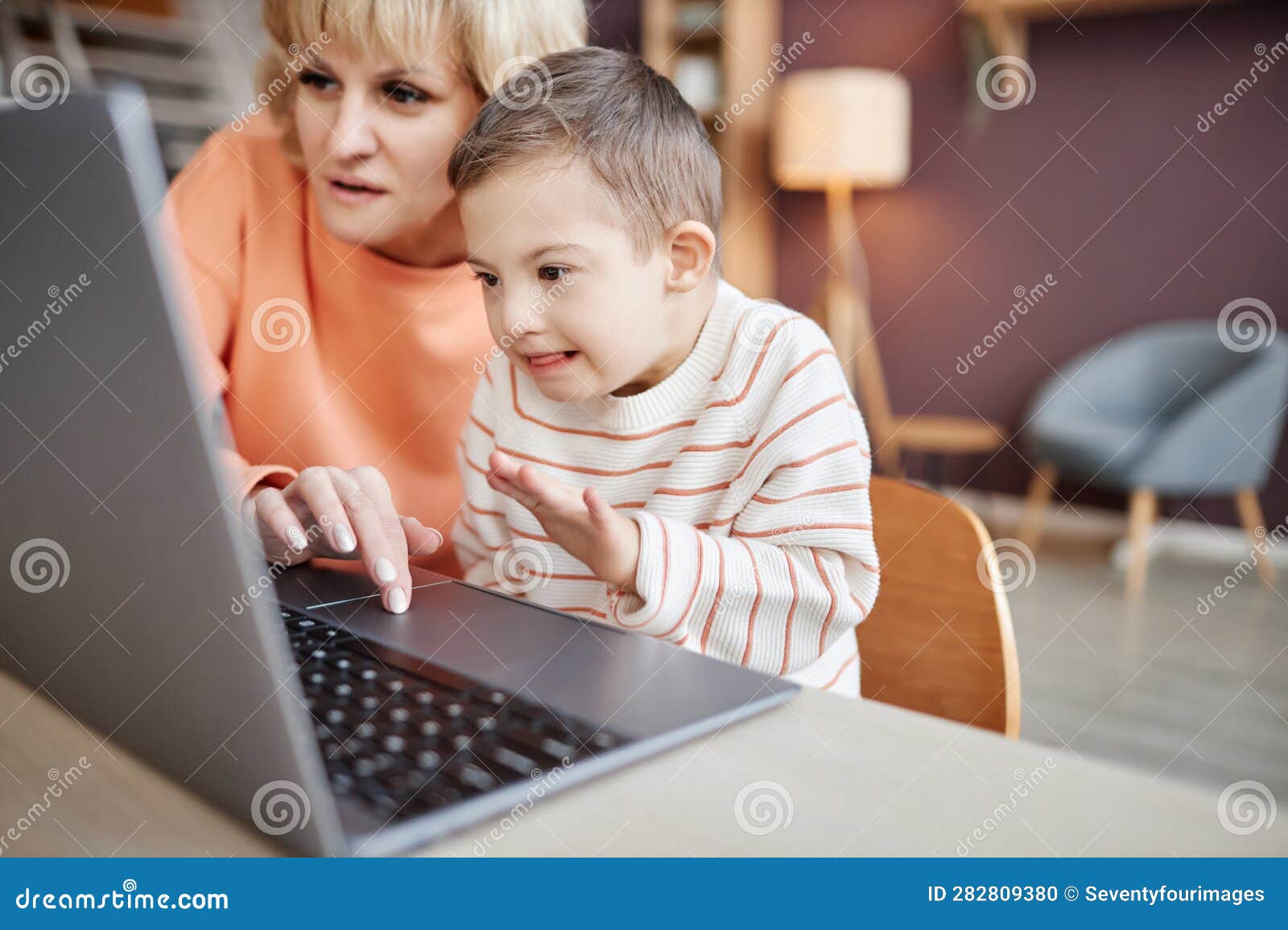 Excited Little Boy with Down Syndrome Using Computer at Home Stock ...