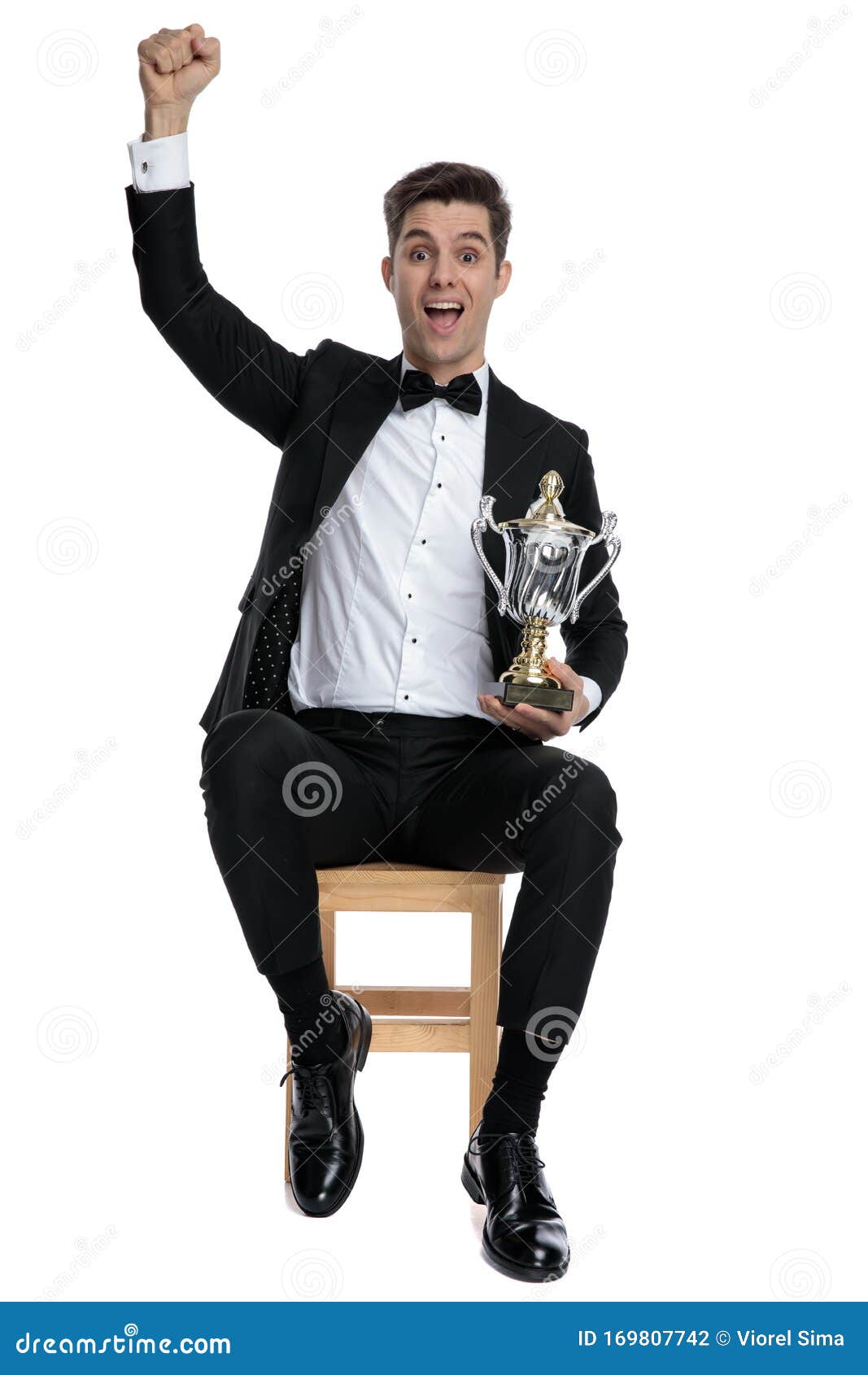 Excited Young Man Celebrating Victory and Holding Trophy Stock Photo ... Excited Young Man Celebrating Victory and Holding Trophy Stock Photo ...