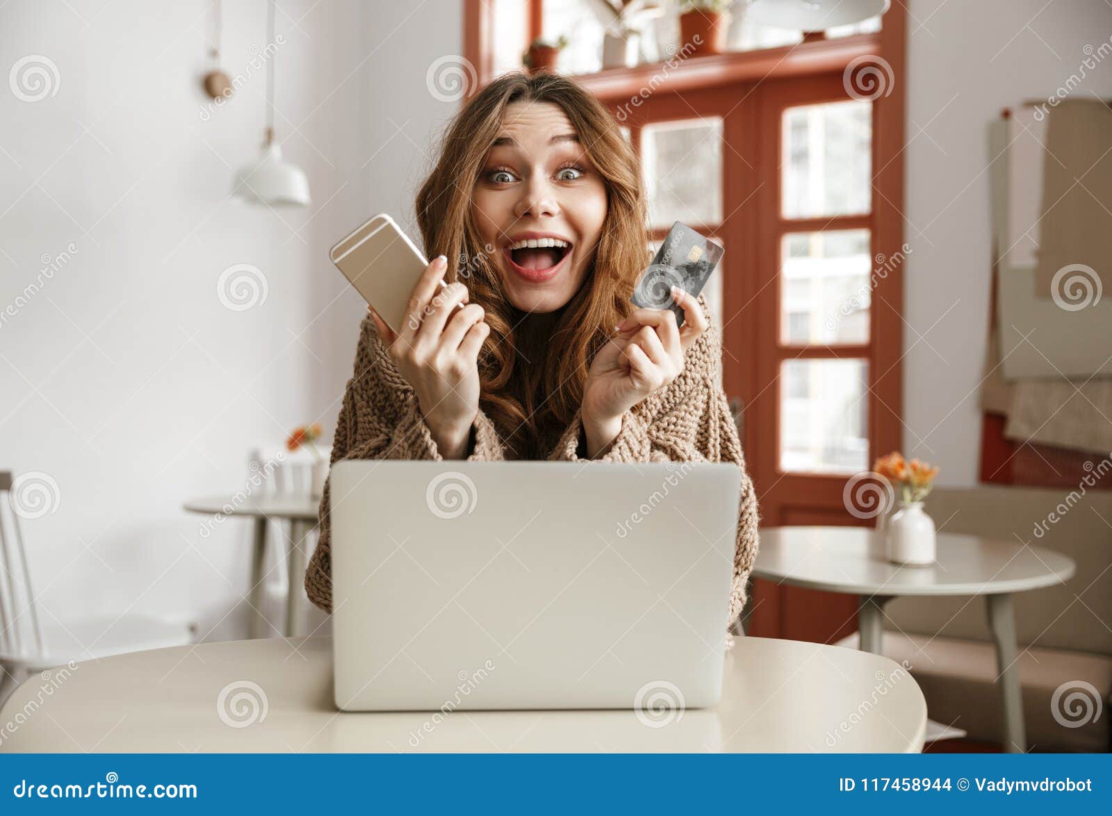 Excited Young Woman 20s Holding Credit Card and Smartphone, while Using ... Excited Young Woman 20s Holding Credit Card and Smartphone, while Using ...