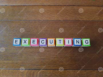 Executing Word in Colorful Letters on Wood Background Stock Photo ...