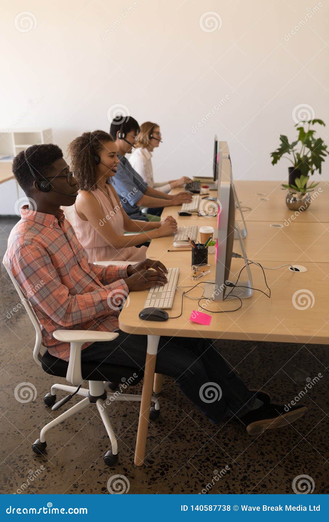 Executives Working on Personal Computer while Talking on Headset in ...