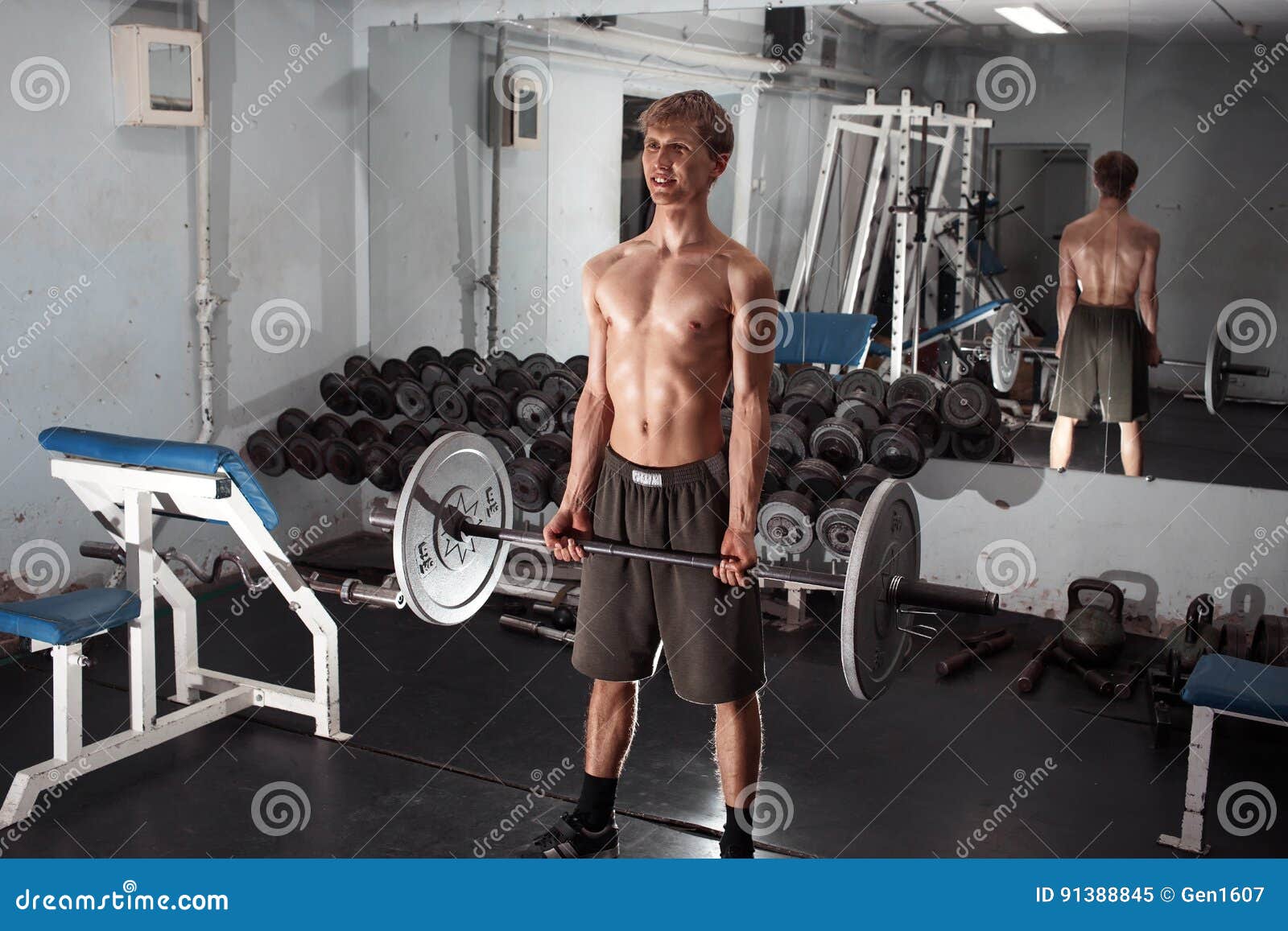 Exercise on the Biceps with the Barbell. a Young Lean Athletic Man ...