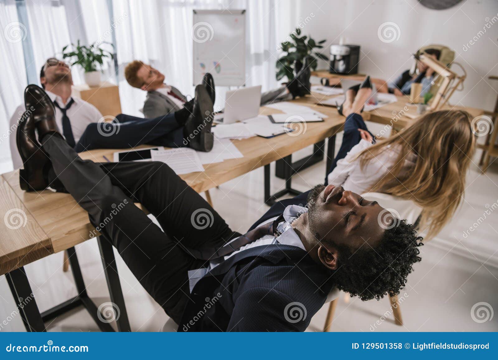 Exhausted Businesspeople Sleeping in Conference Hall with Feet Stock ... Exhausted Businesspeople Sleeping in Conference Hall with Feet Stock ...
