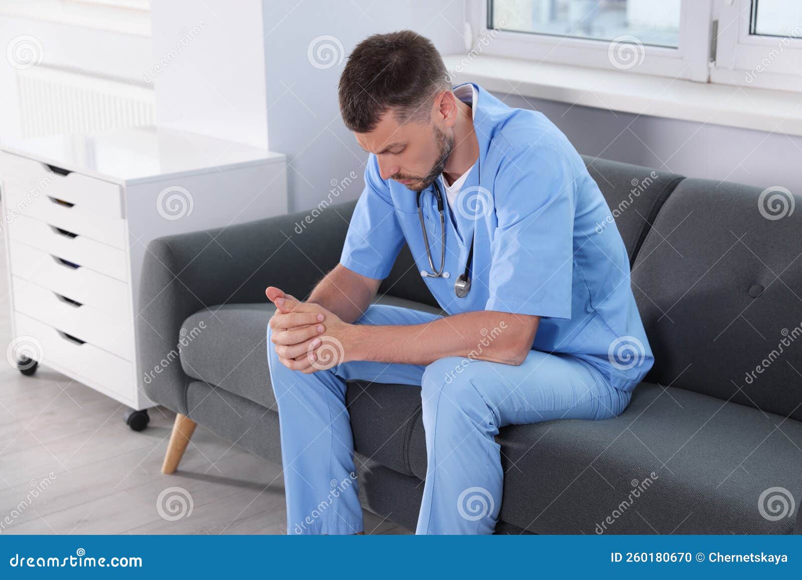 Exhausted Doctor Sitting on Sofa in Hospital Stock Photo - Image of ...