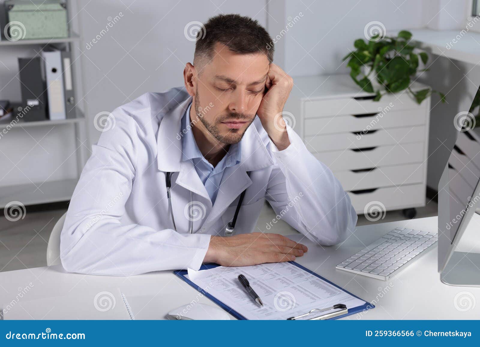 Exhausted Doctor Sleeping at Workplace in Hospital Stock Photo - Image ...