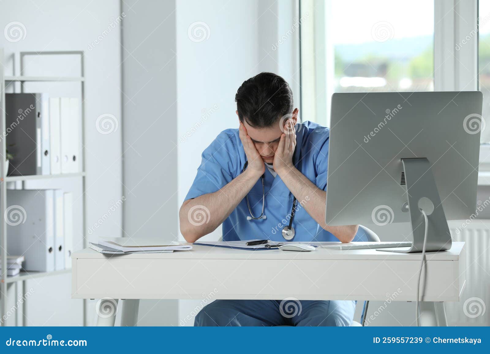 Exhausted Doctor Working at Table in Hospital Stock Image - Image of ...