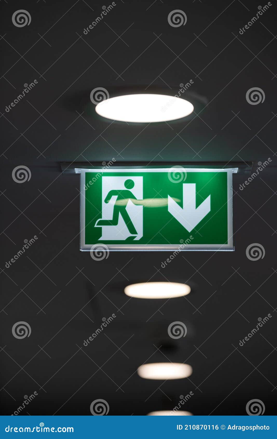 Exit Sign Detail On The Ceiling Of An Office Building With Dark ...