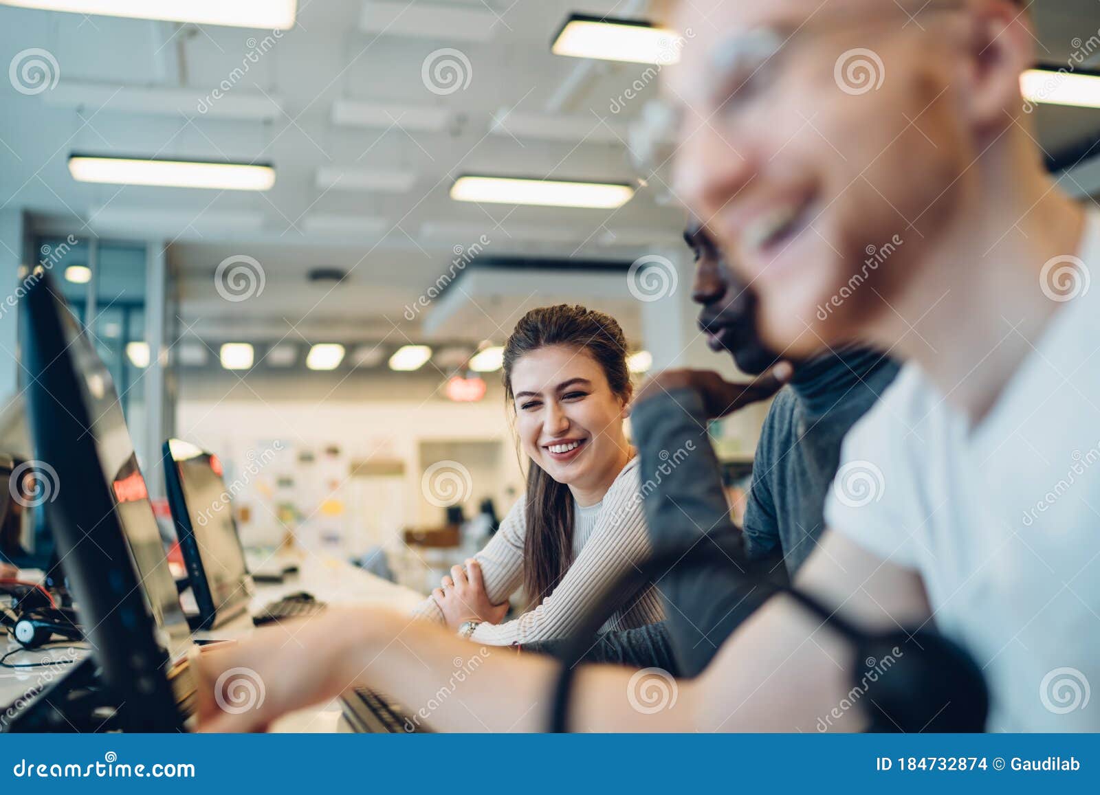 Exited Multiracial Students Having Fun while Using Computer in Library ...