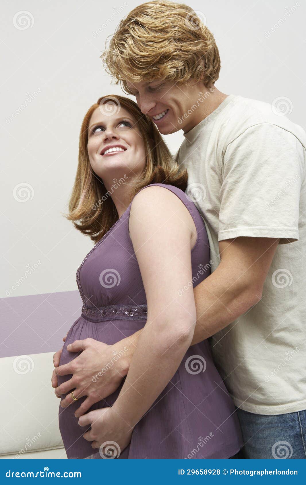 Expectant Couple Looking at Each Other while Embracing Stock Photo ...
