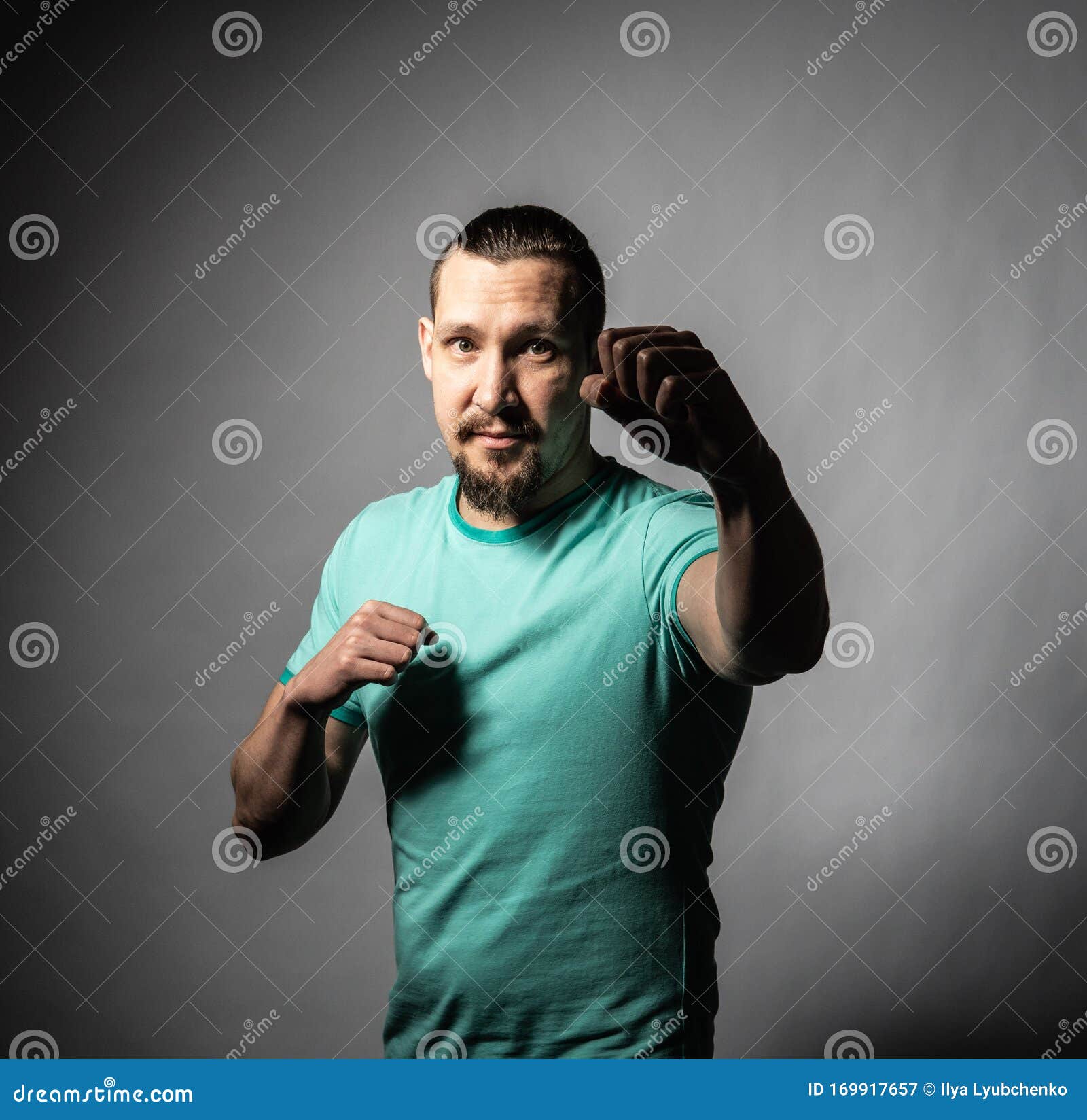 Experienced Boxer Shows Boxing Techniques in a T-shirt on a Gray ...