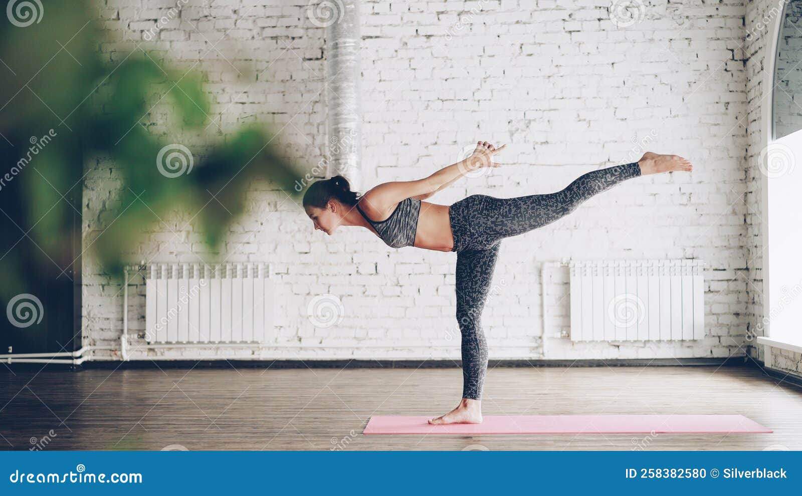 Experienced Yoga Teacher is Practicing Standing Half Forward Bends and ...