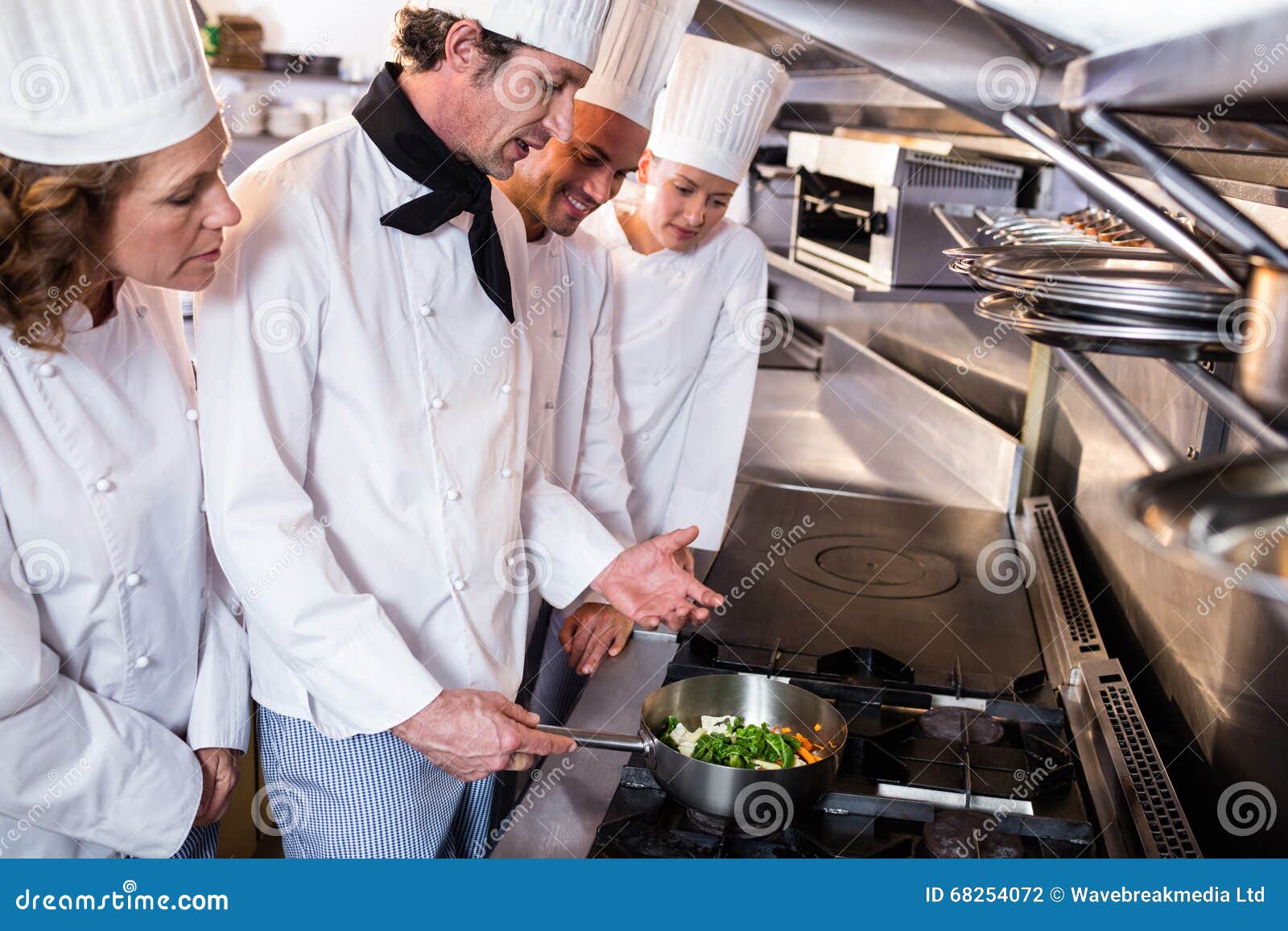 Experienced Head Chef Explaining To His Colleagues in the Kitchen Stock ...