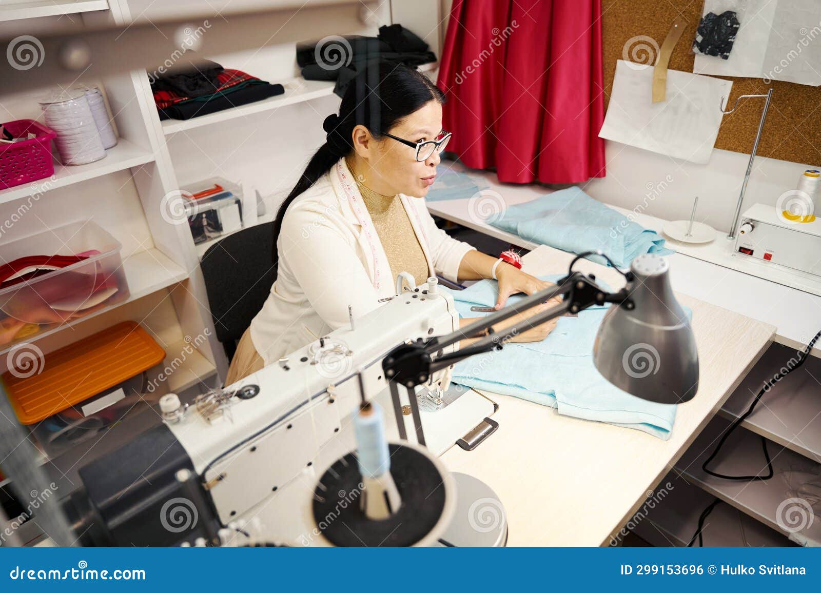 Experienced Tailoring Master at Workplace Working with Blue Fabric ...