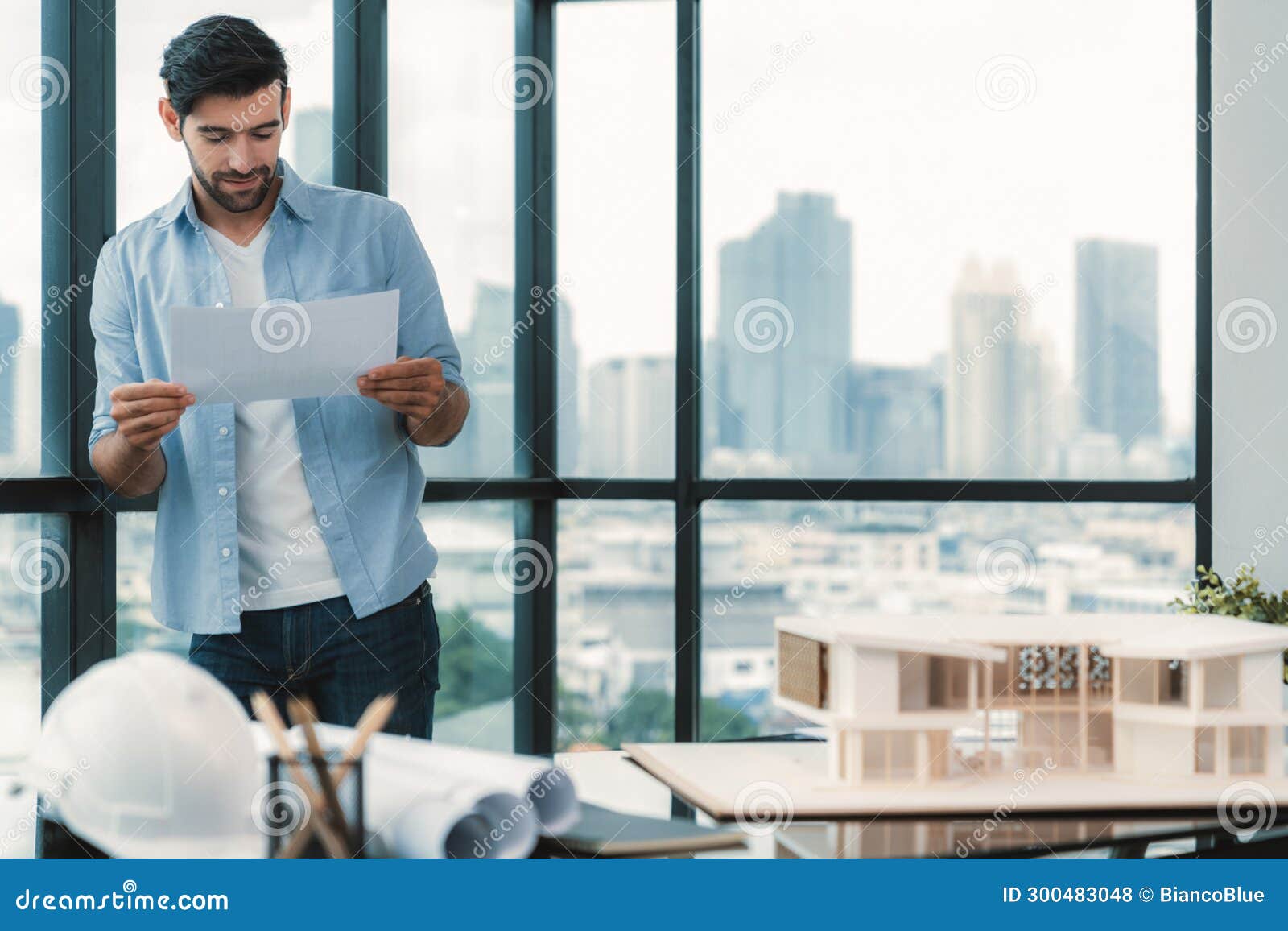 Expert Engineer Holding Blueprint while Comparing with House Model ...