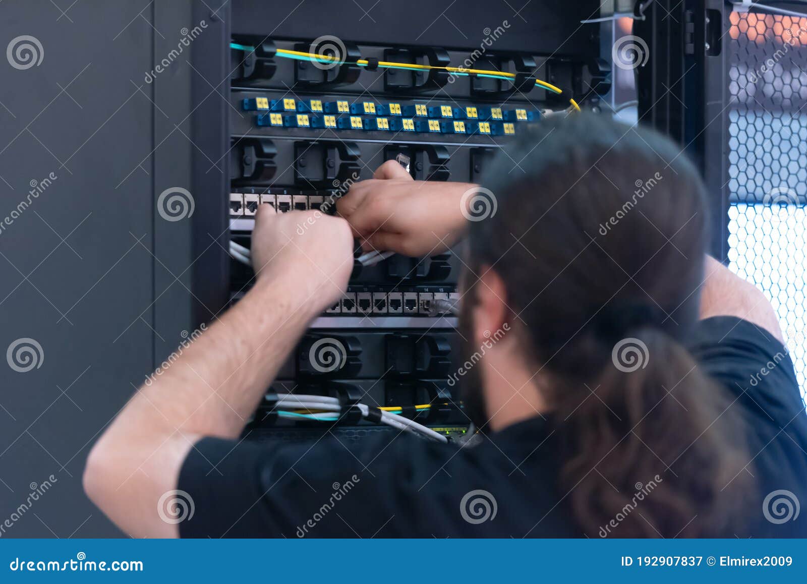 An Expert Engeneer in Datacenter Server Room Connecting Cables in ...