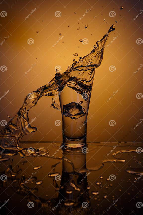 Exploding Glass Cup with Water Shattering Over Orange Background. Stock ...